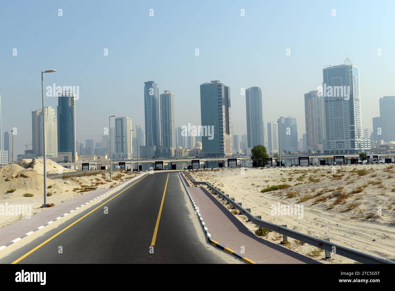 New modern skyline rising from the sand dunes in Sharjah, UAE Stock ...