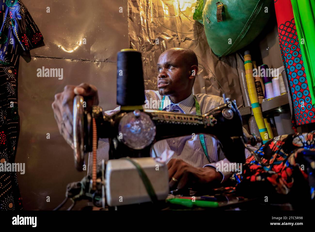 Richard Onyango a tailor at Afrowema thrifts fabric clothes at his ...