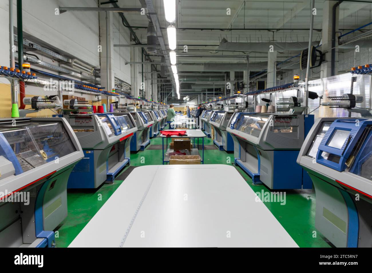 A row of industrial textil flat knitting machines in a knitwear factory ...