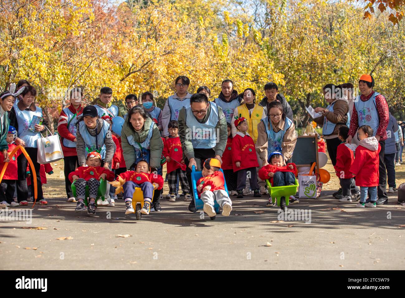 Children and their parents take part in a fun games at a park in Jinhua ...