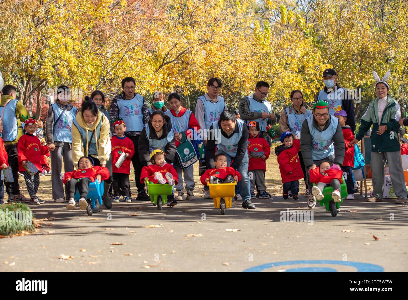 Children and their parents take part in a fun games at a park in Jinhua ...