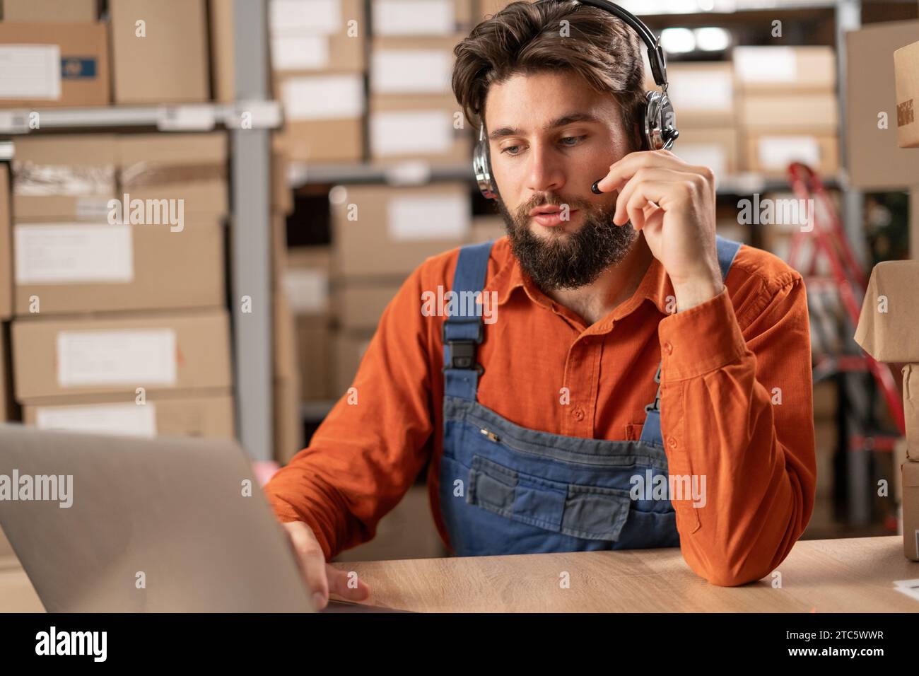technical support operator at a delivery warehouse works at a laptop ...