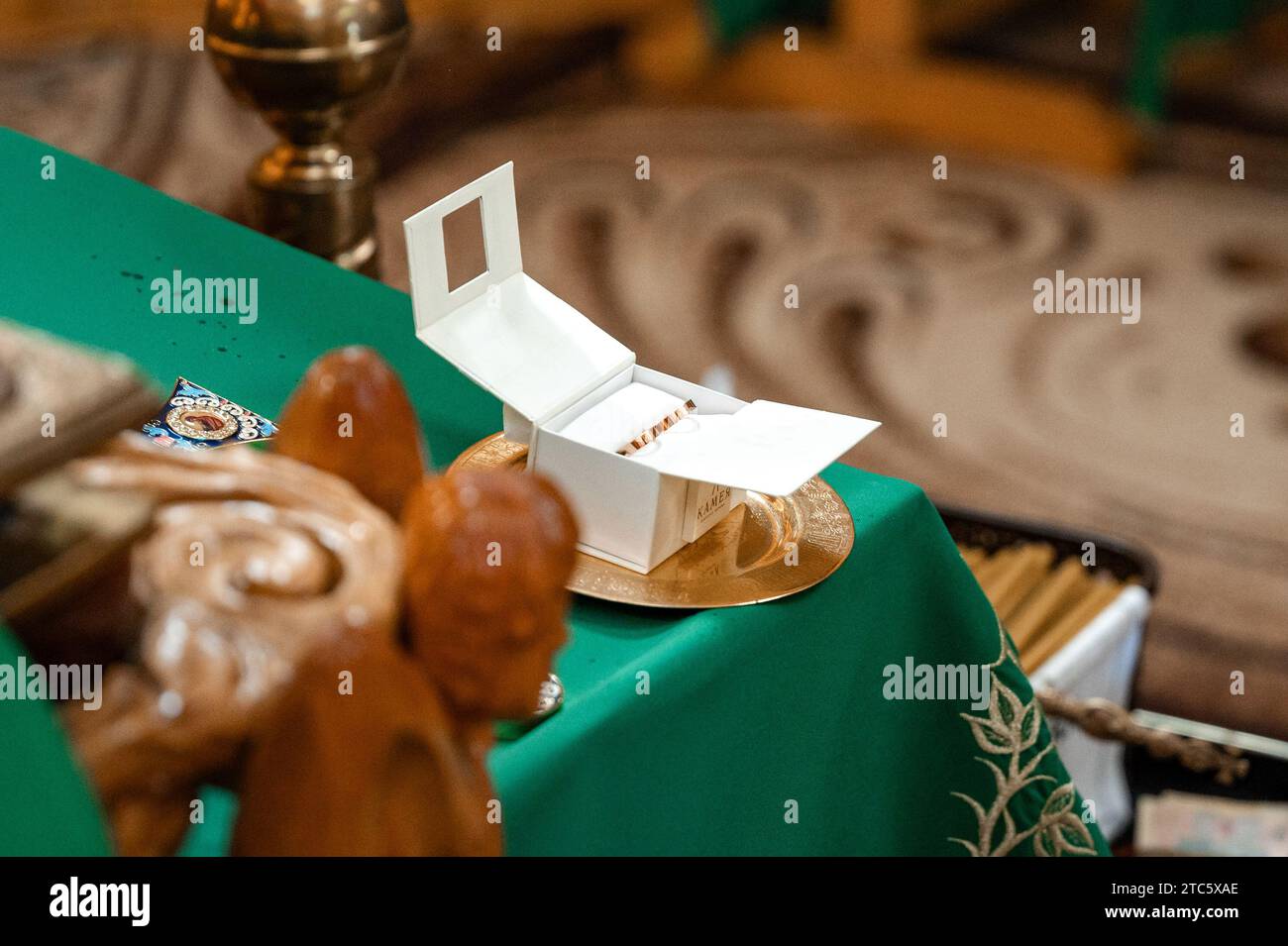 Wedding rings stand on a tray in the church for consecration with water ...