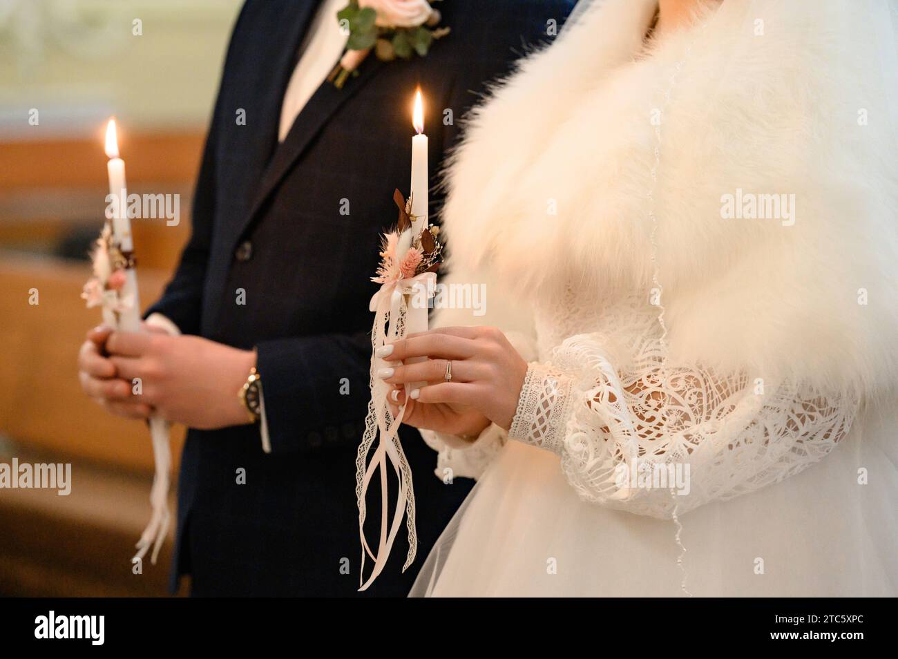 The bride and groom hold lit candles in their hands, wedding traditions ...
