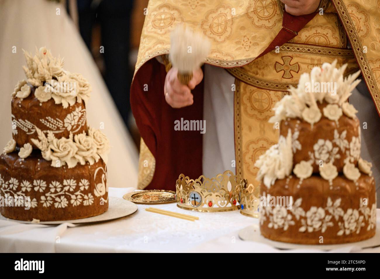 The priest consecrates the wedding rings of the bride and groom with ...