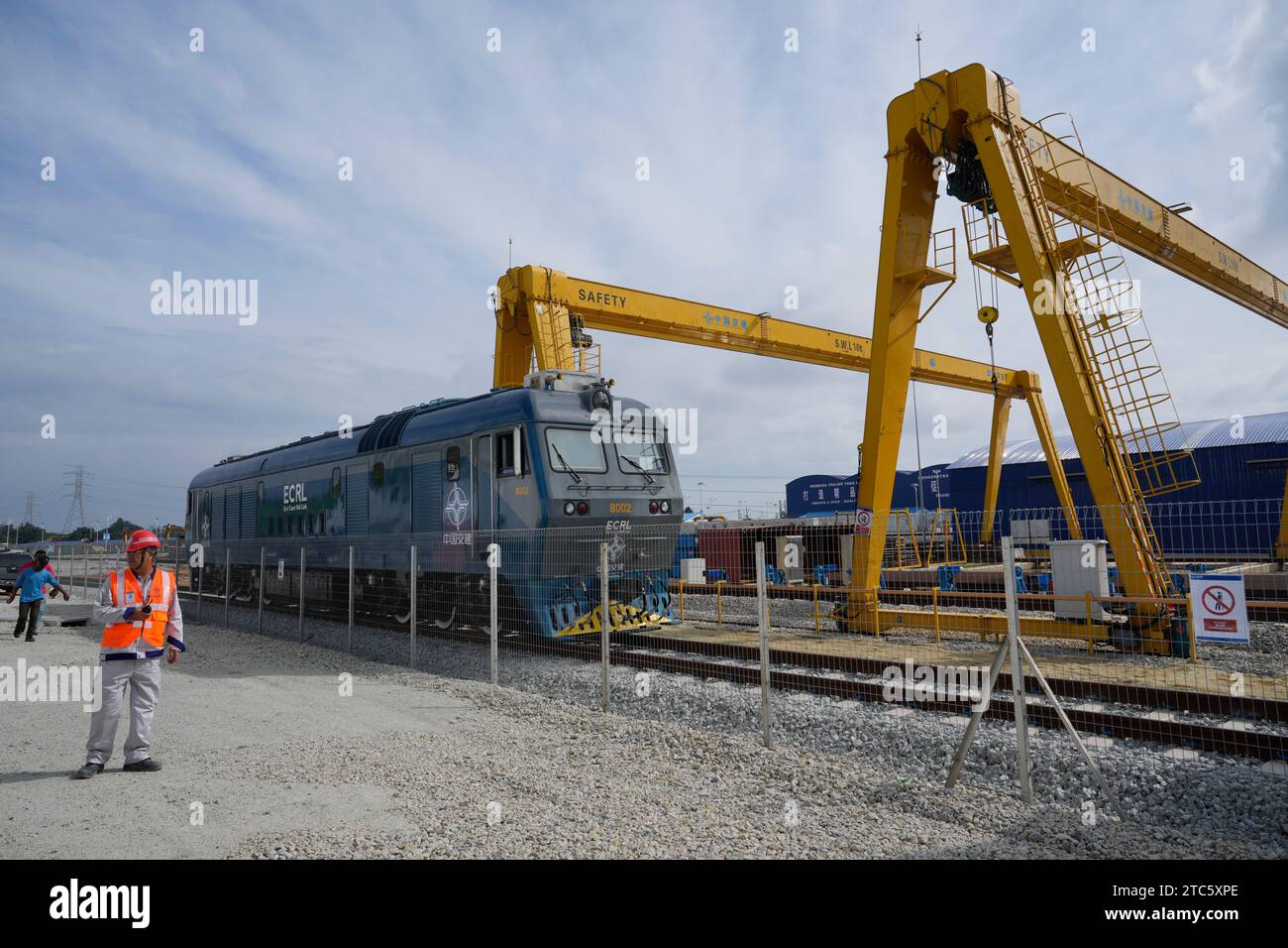 A worker stands next to construction site for the East Coast Rail Link ...