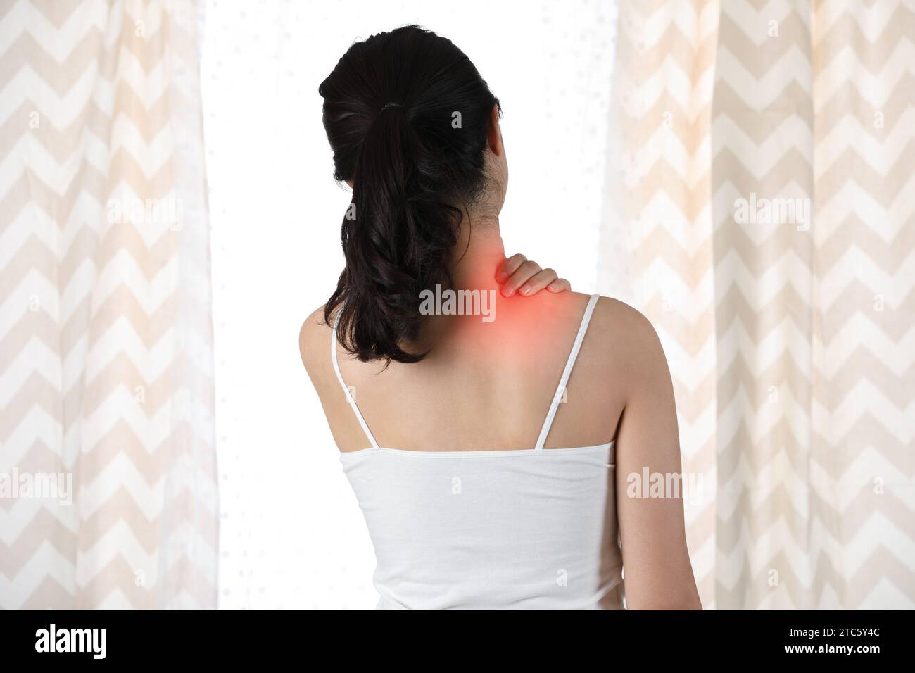 A woman suffering from back neck pain is holding the back of her neck ...