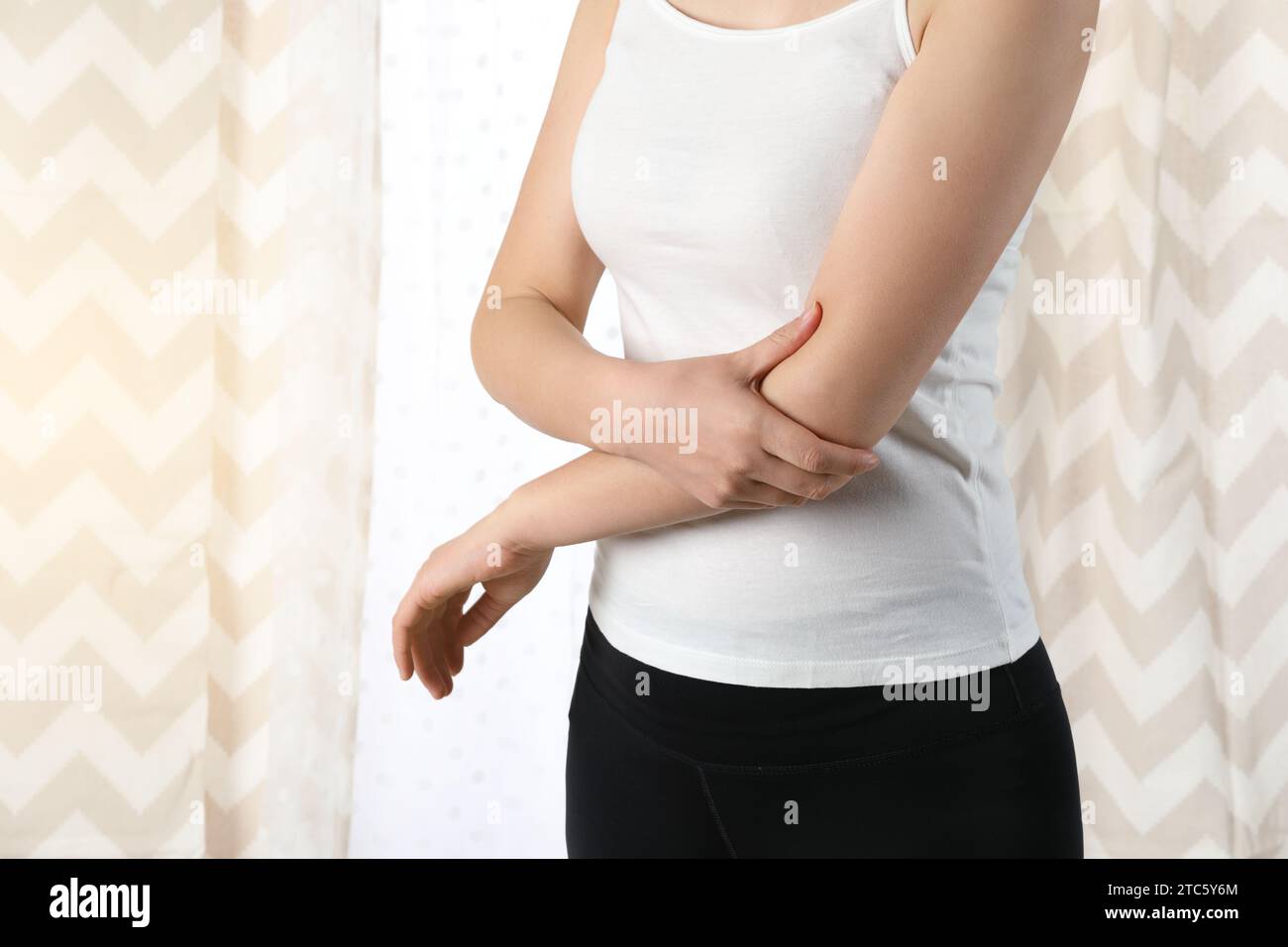 Woman suffering from elbow arthritis is touching her elbow Stock Photo ...