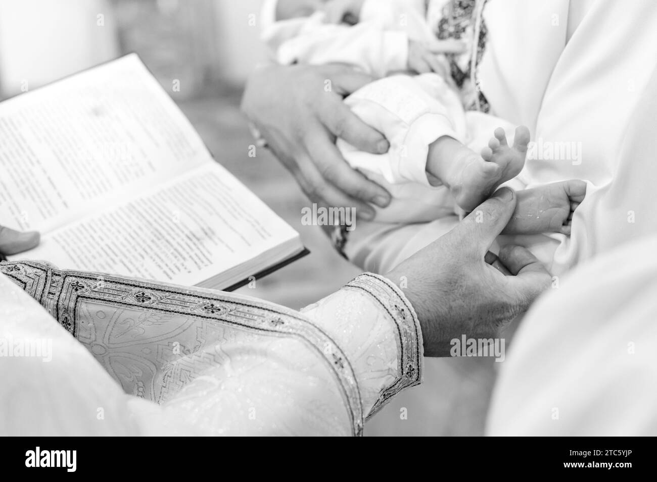 The priest performs the rite of baptism of the child and anoints the ...