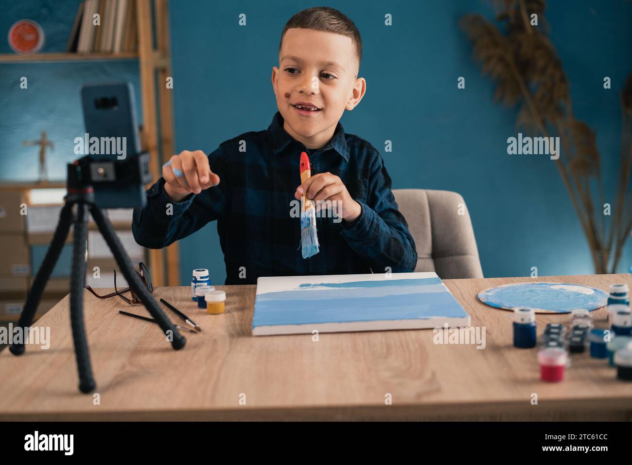 Artist boy painting with watercolors and making videos for his channel ...