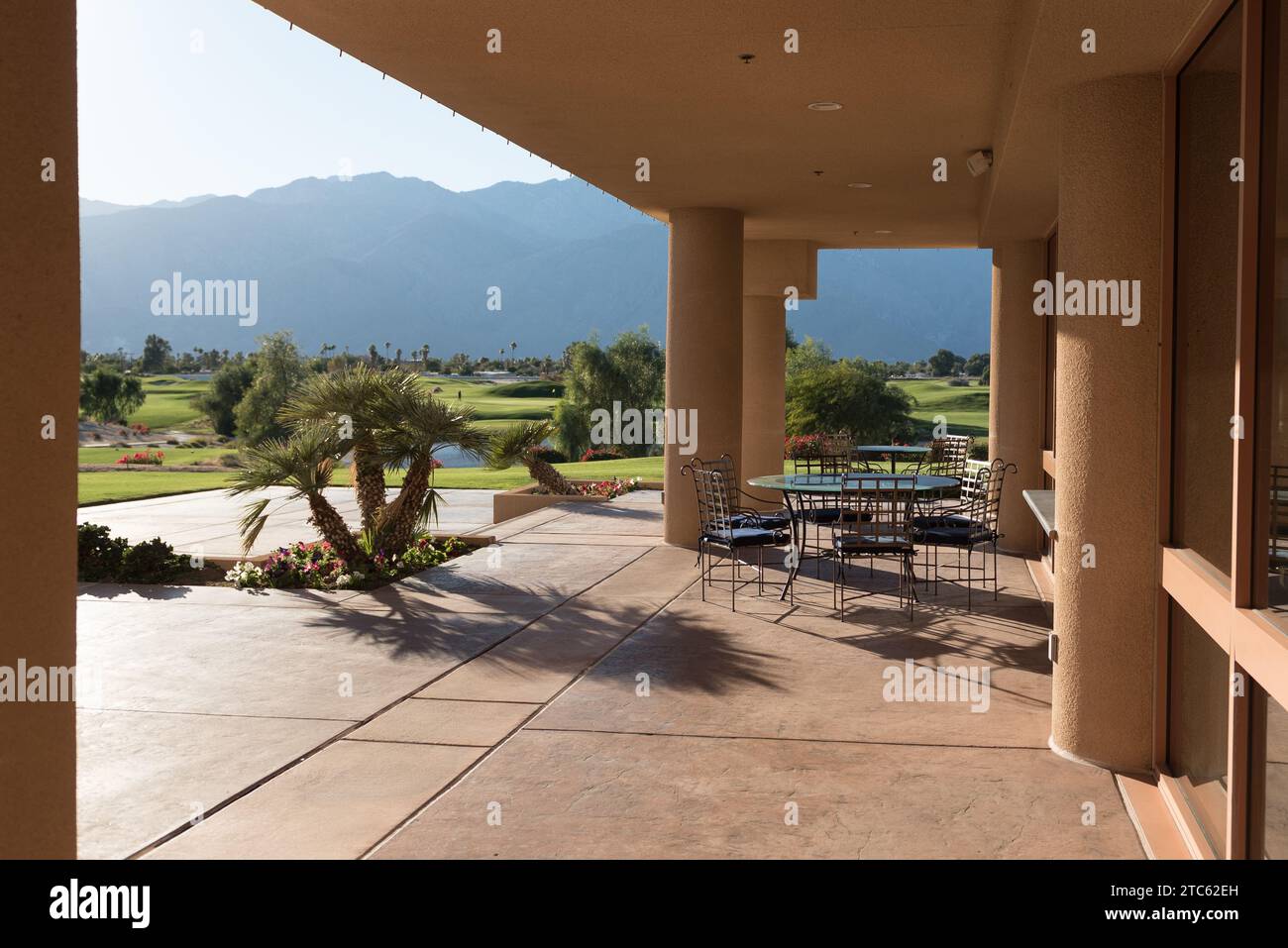 A terrace of a clubhouse overlooking a golf course in a desert ...