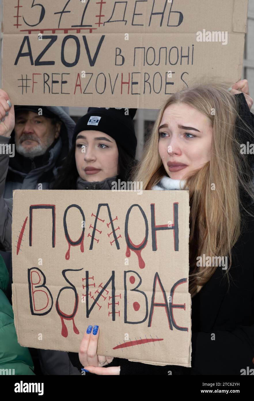 A POW's wife is seen in tears holding a placard with the words ...
