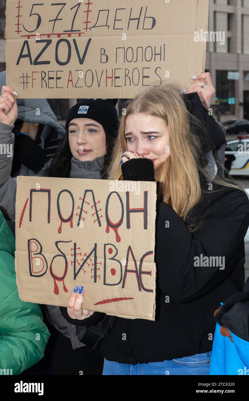A POW's wife is seen in tears holding a placard with the words ...