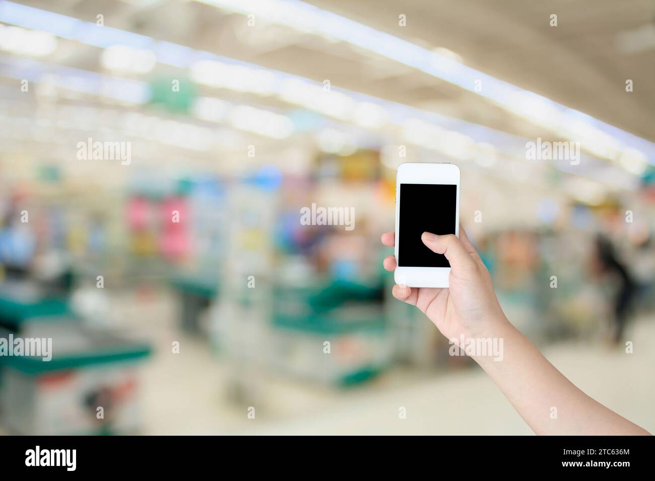 Hand use smartphone with Supermarket store background ,Cashier counter ...
