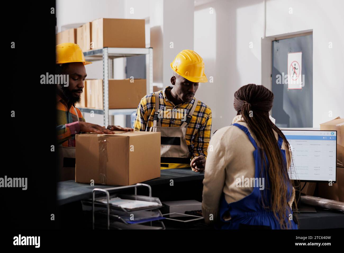 Postal service worker examining packed parcel before delivery at ...