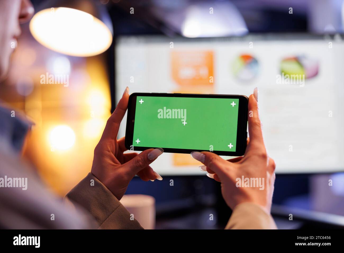 Businesswoman holding smartphone with green screen chroma key mock up ...