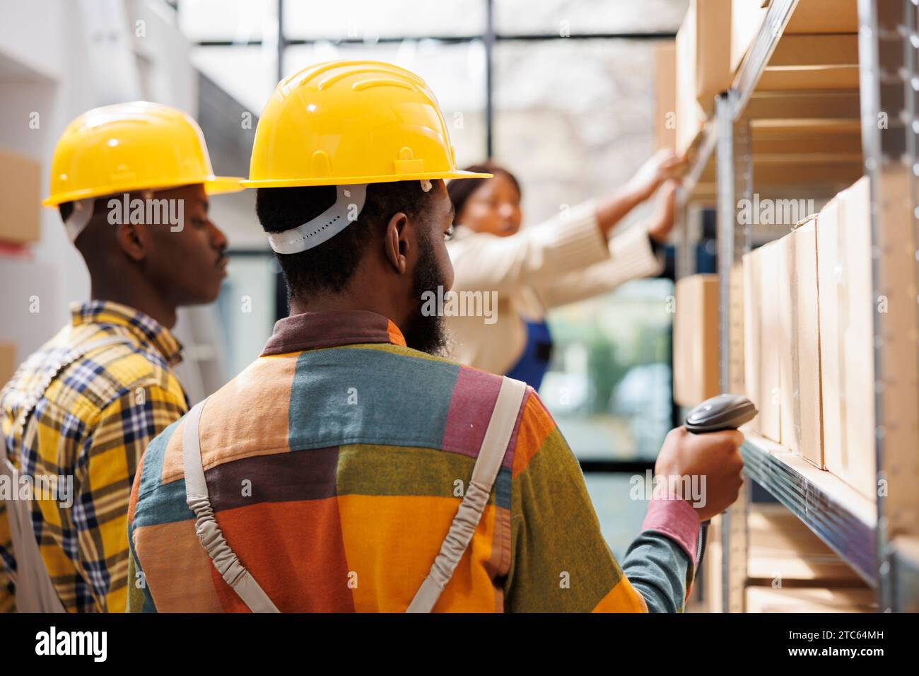 African american logistics managers scanning freight in storage ...