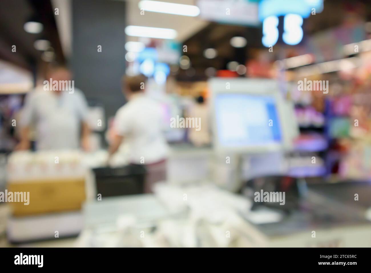 Supermarket cashier checkout counter with customer defocused blur ...