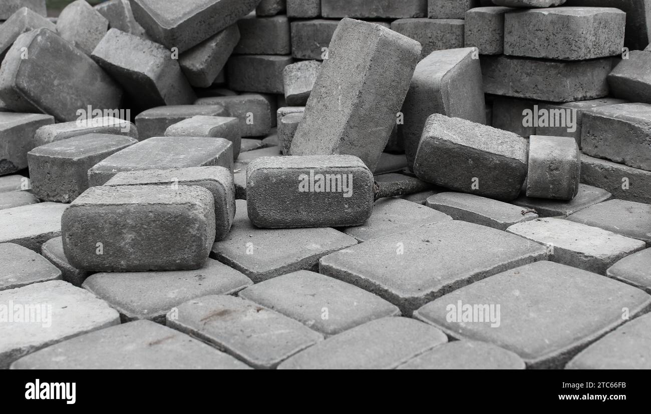 Pavement tiles laid out on a flat surface in front of a pile of similar ...
