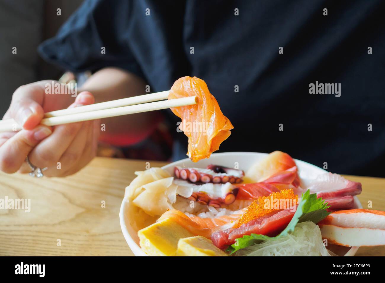 Salmon slice in chopsticks, Eating Sashimi Rice Bowl Chirashi Don ...