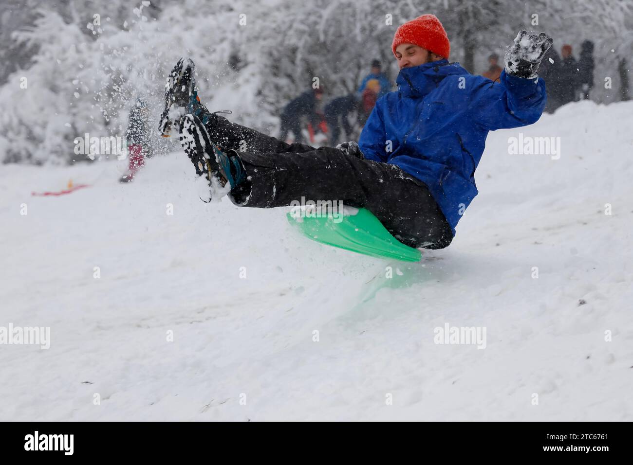Man sleighing down a snowy hill flying through the air in Munich ...