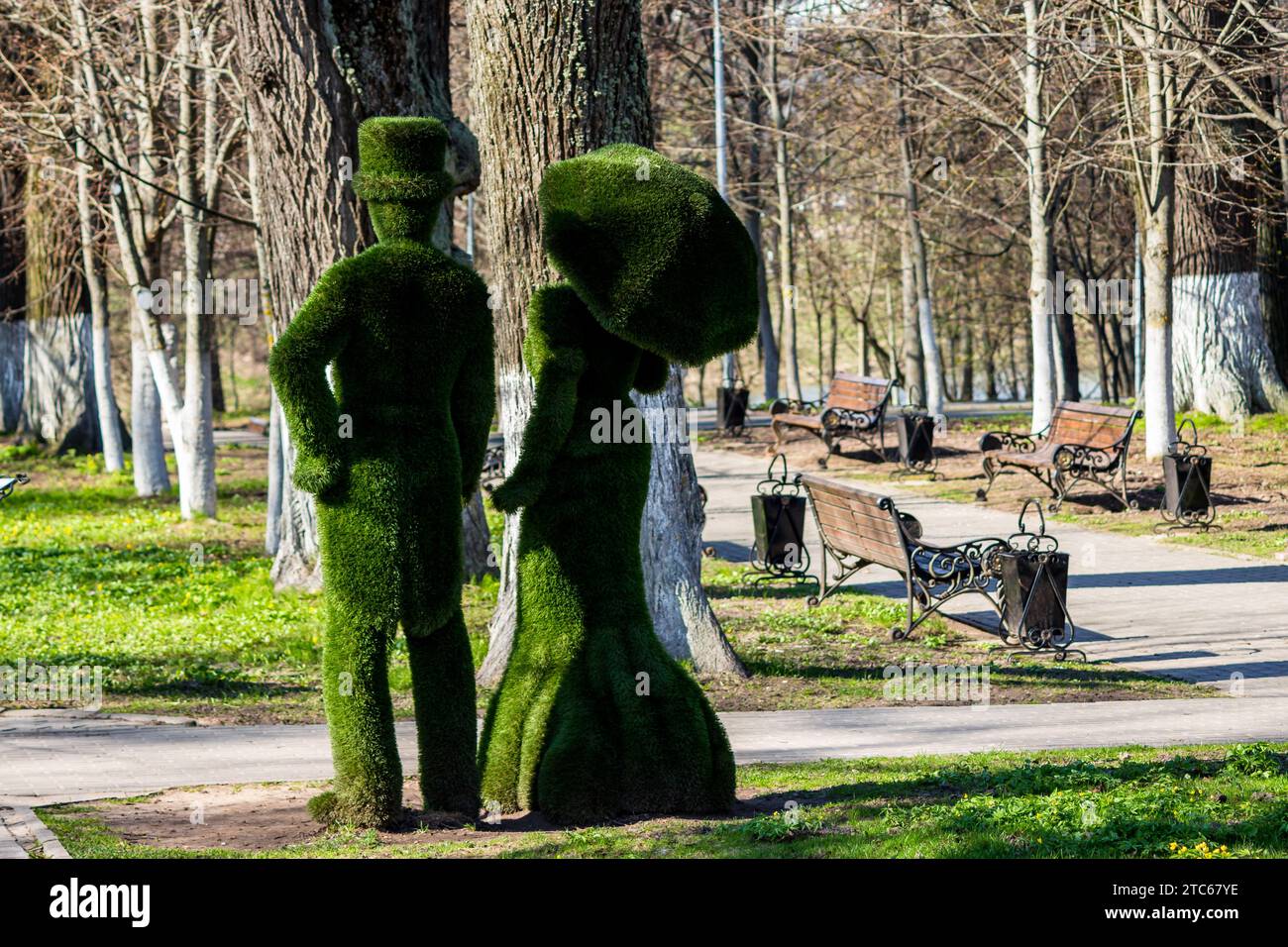 Artificial topiary figures depicting a walking couple in a city park ...