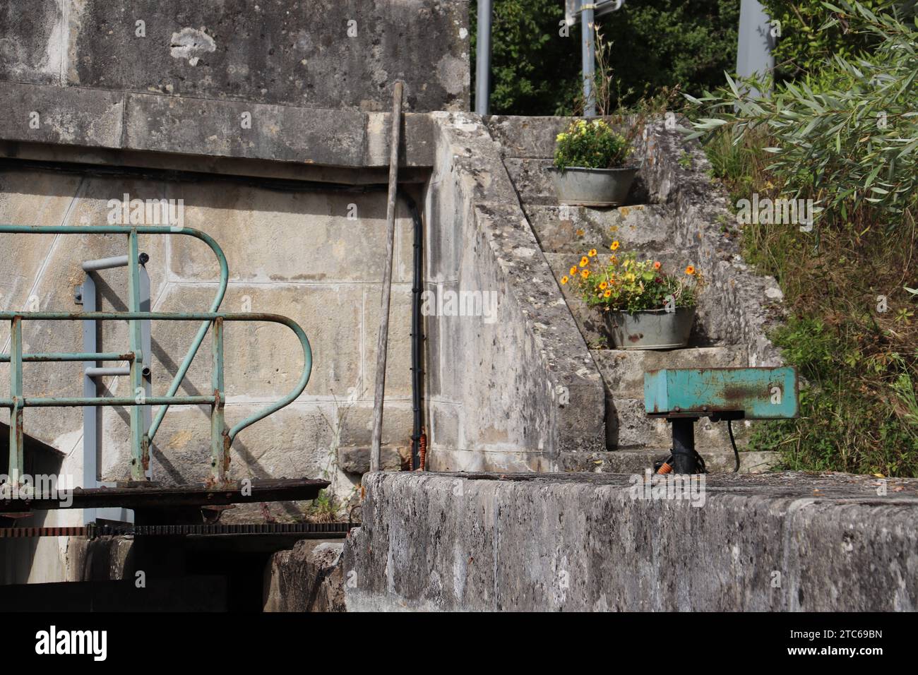 A concrete building with stairs leading up to its entrance, surrounded ...