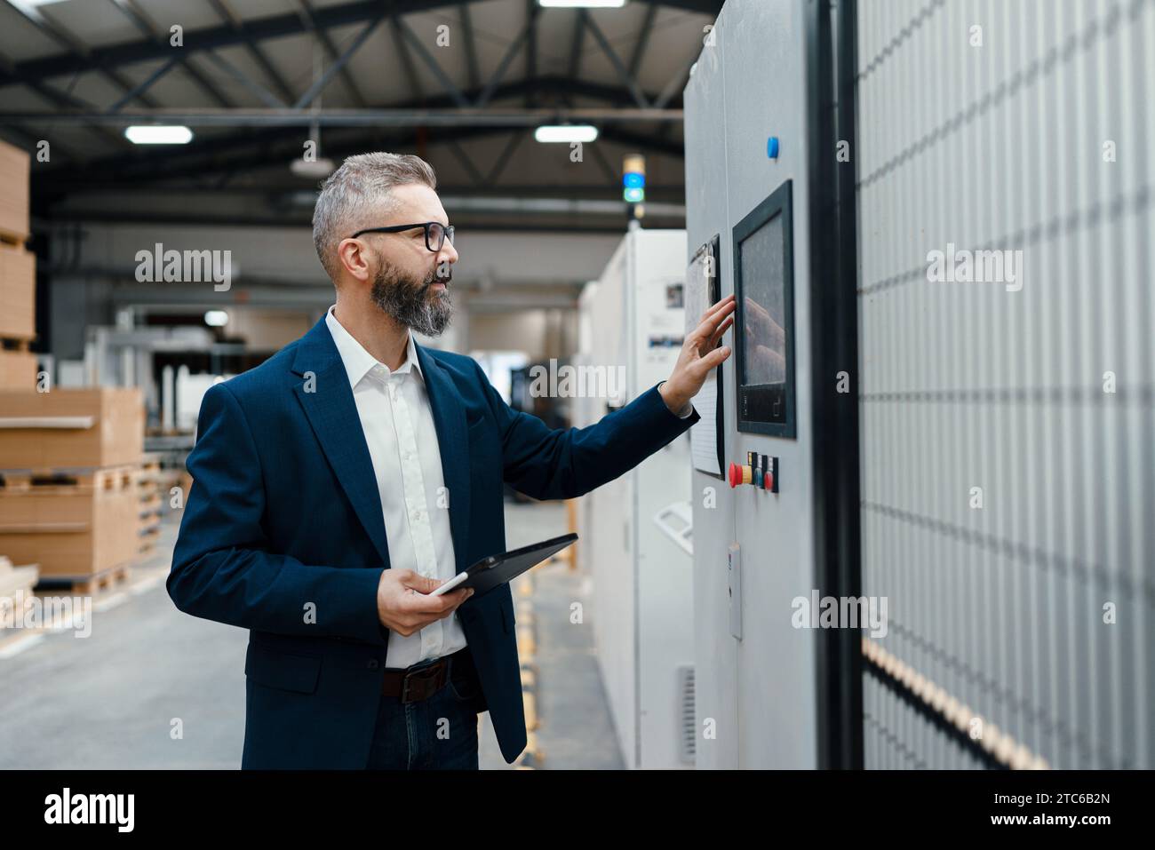 Production manager standing by control panel in modern industrial ...