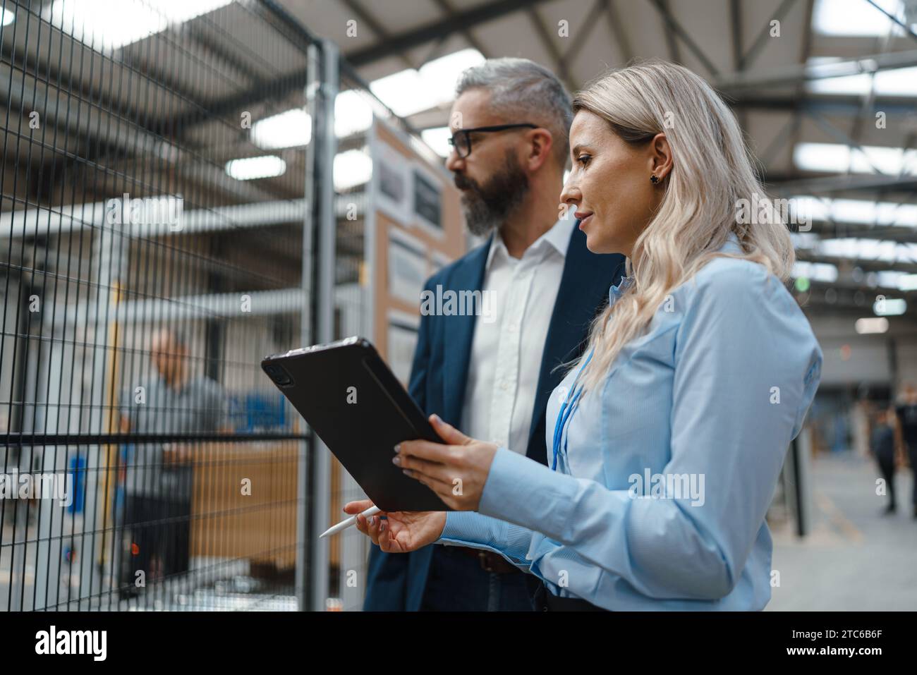 Female engineer and male production manager standing in modern ...