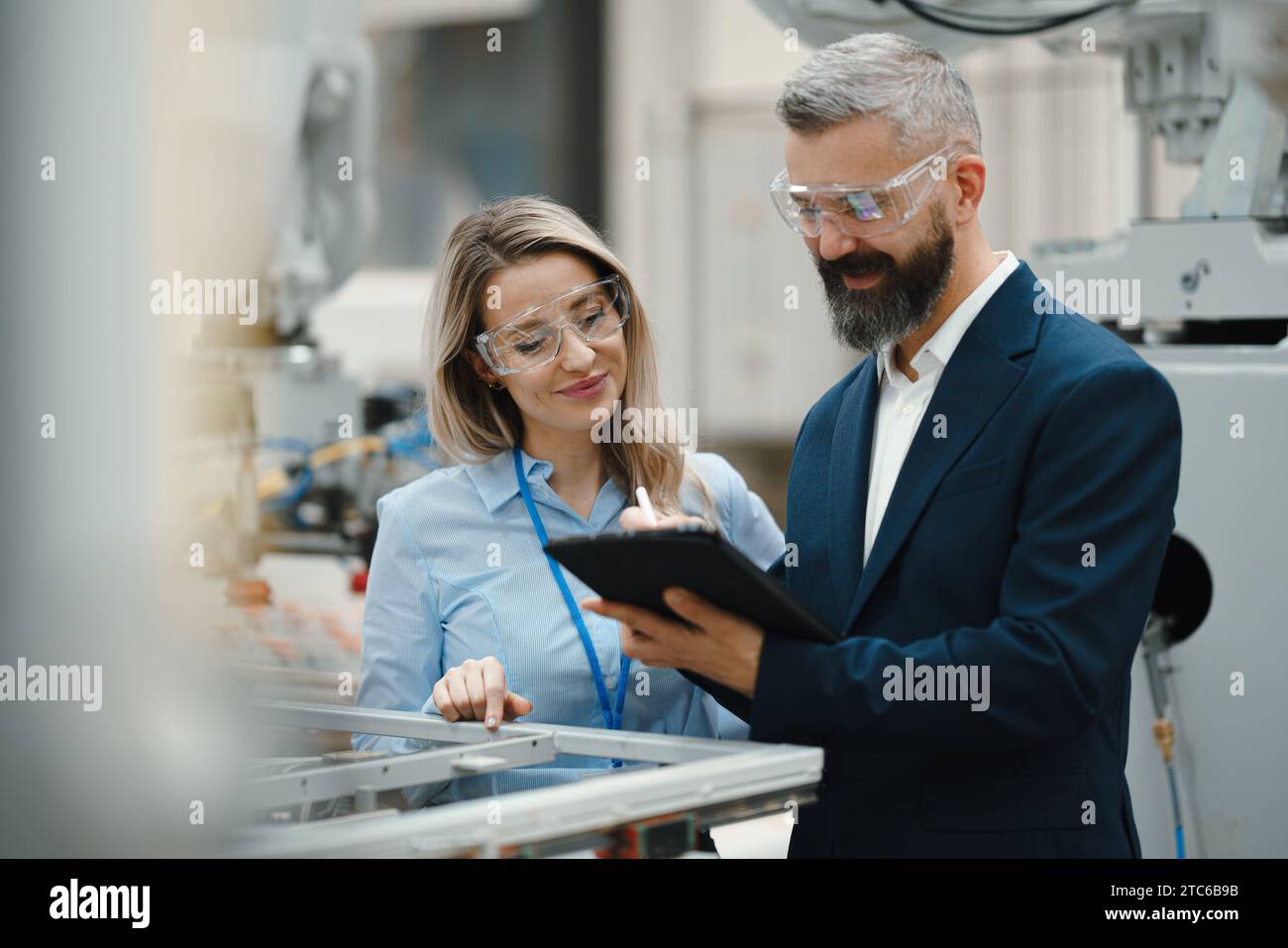 Female engineer and male production manager standing in modern ...