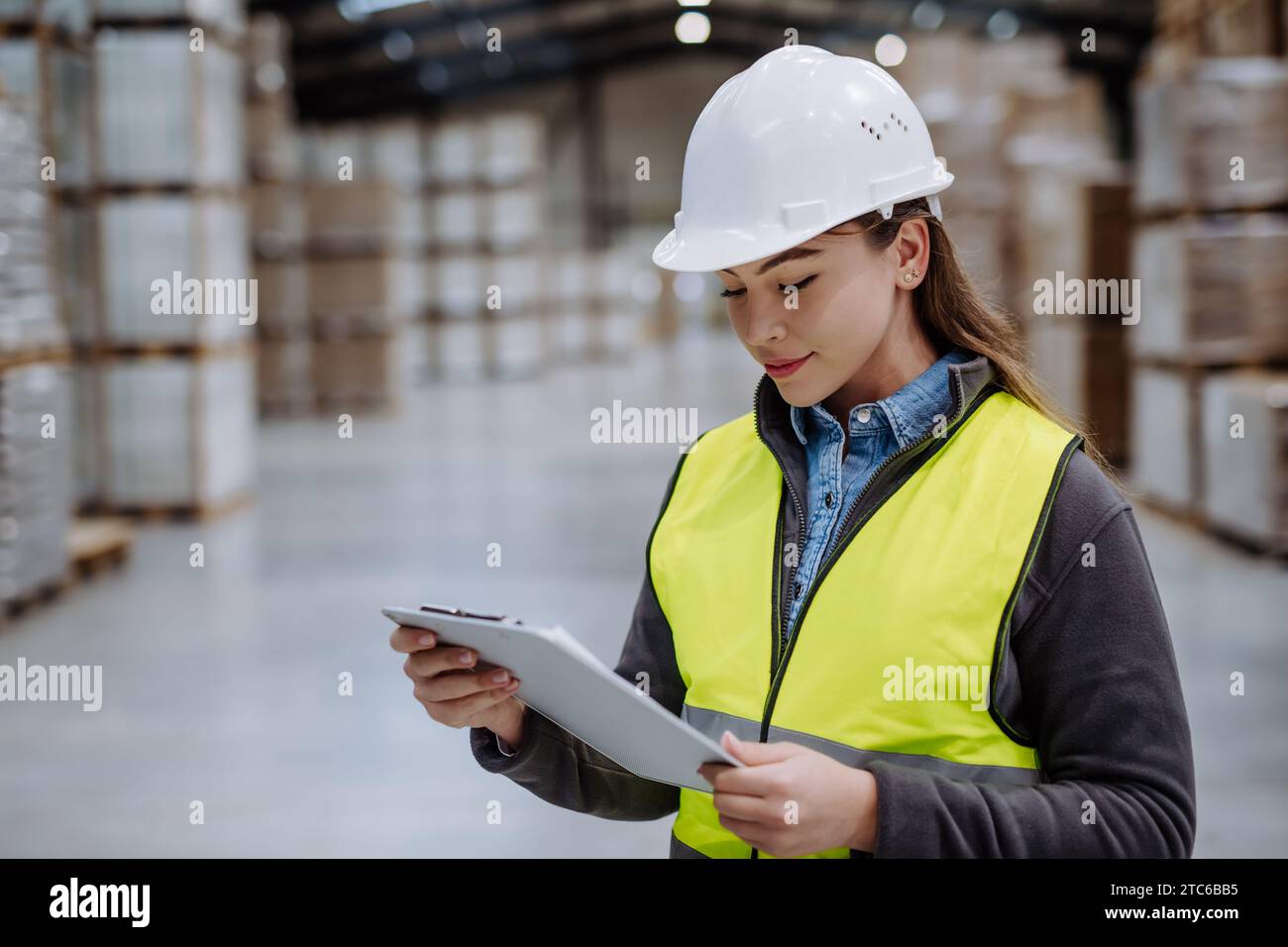 Female warehouse worker reading product order, order picking. Warehouse ...