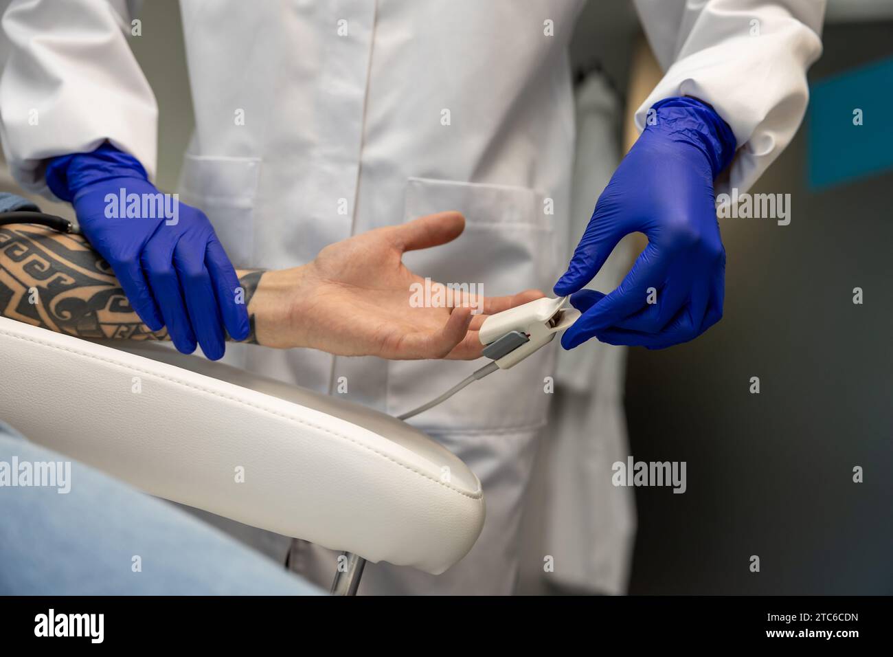 Nurse measuring pressure and oxygen level in male finger Stock Photo ...