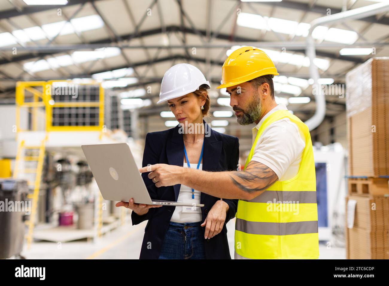 Female manager talking with foreman, checking production plan on ...