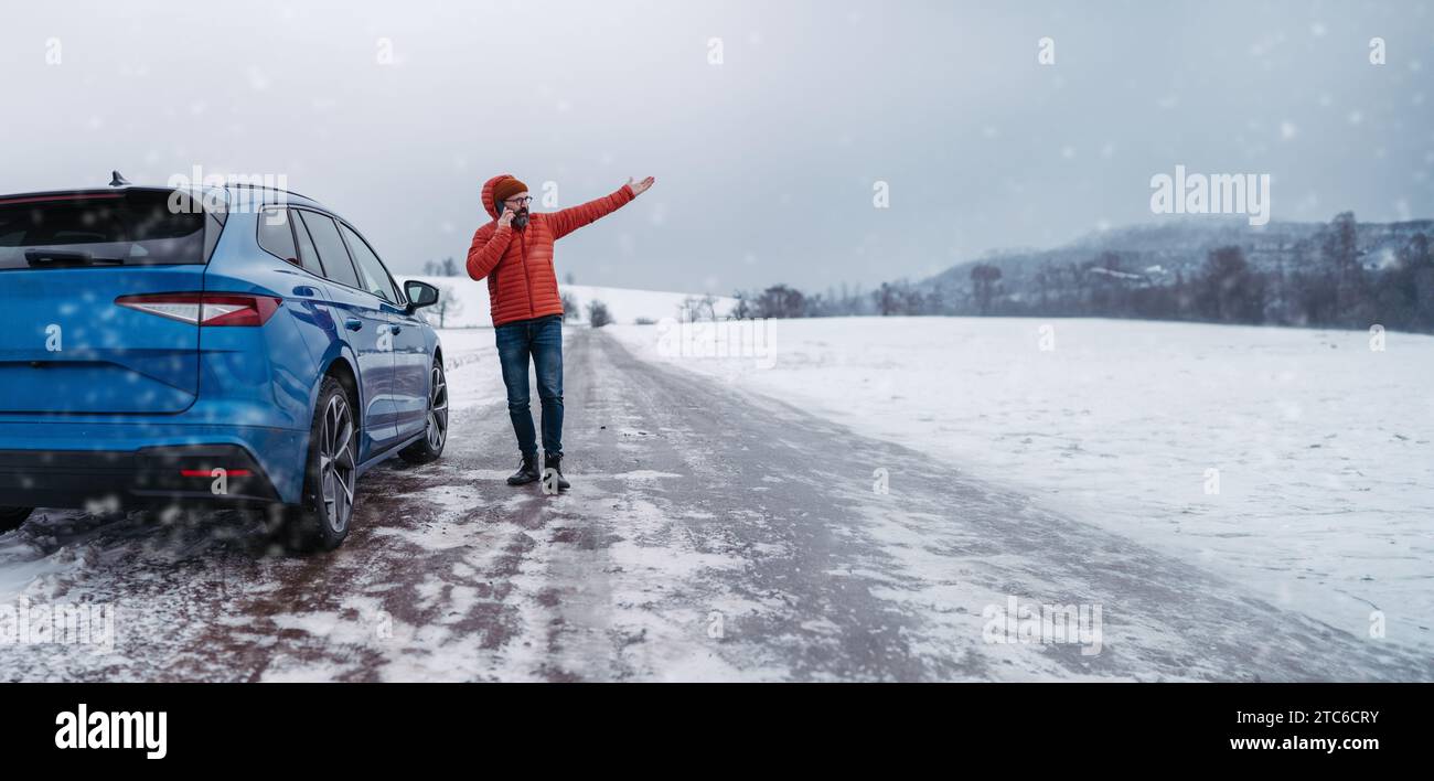 Angry man standing by electric car, battery run out of power before ...