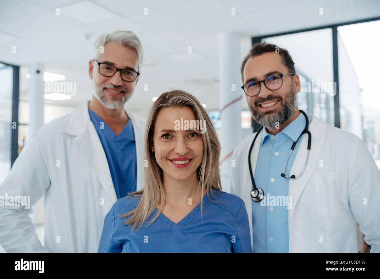 Portrait of confident three doctors standing in Hospital corridor. Medical team wearing white ...