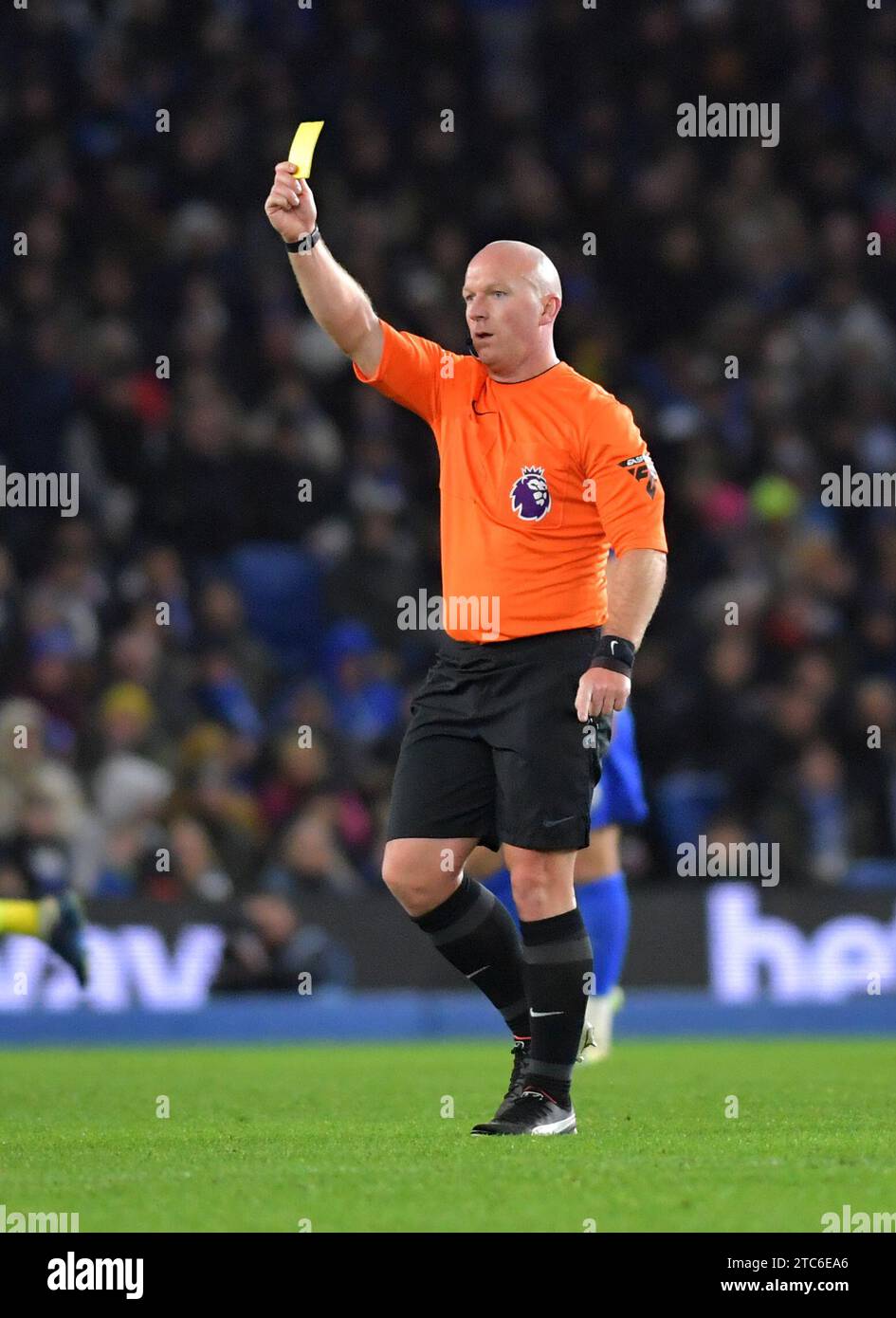 Referee Simon Hooper brandishes a yellow card during the Premier League ...