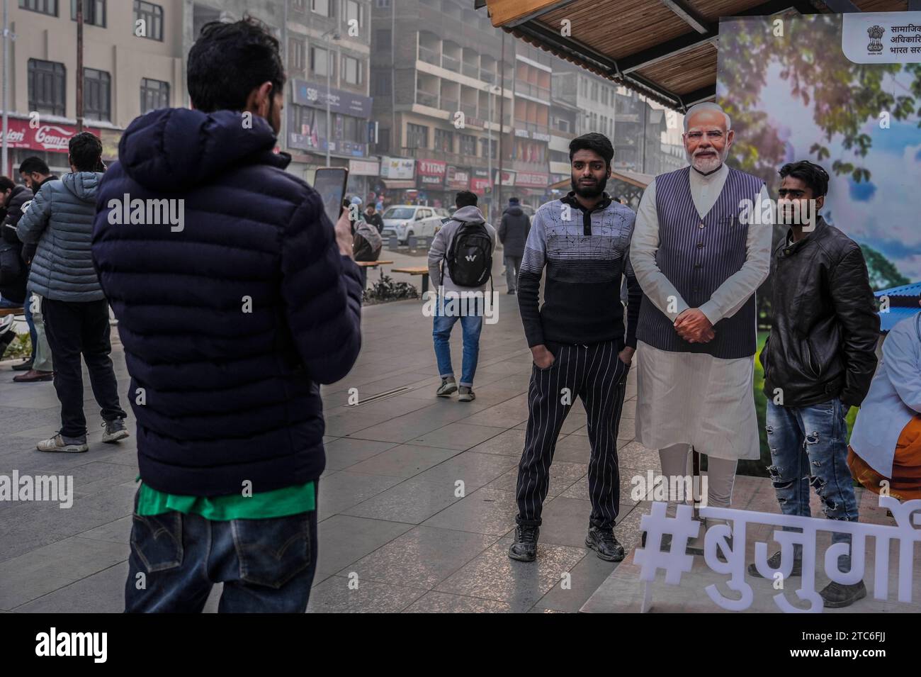 People pose for photographs with a cutout portrait of Indian Prime ...