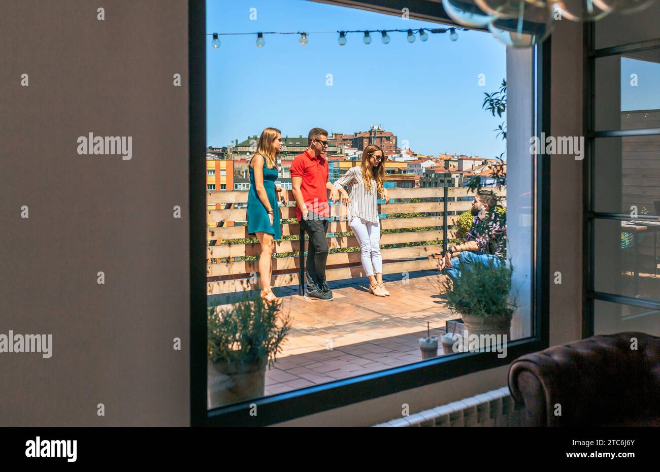 View of friends group talking in rooftop through lounge window Stock ...