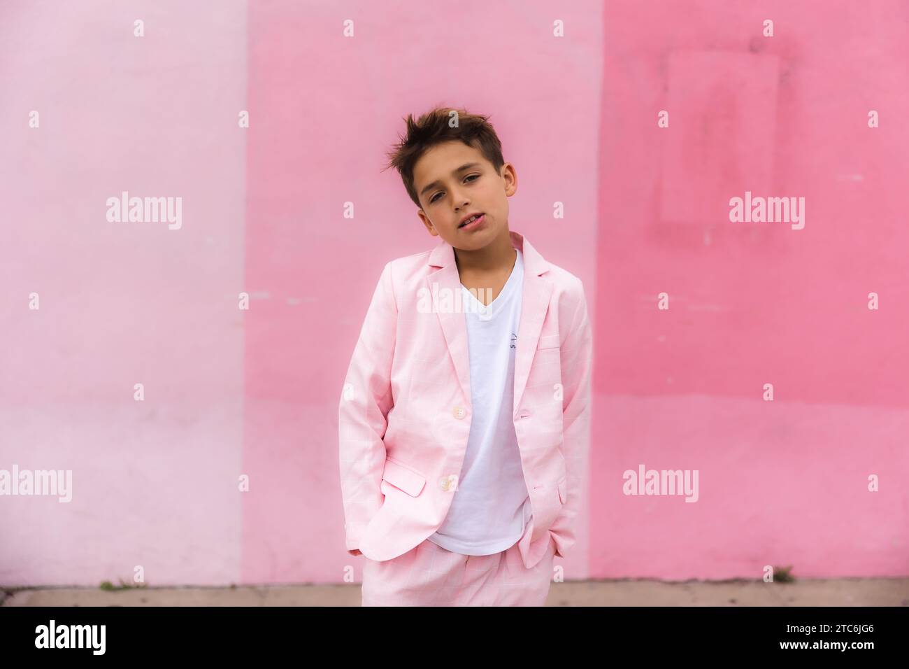 Young boy all pink posing on the sidewalk in a suit Stock Photo - Alamy