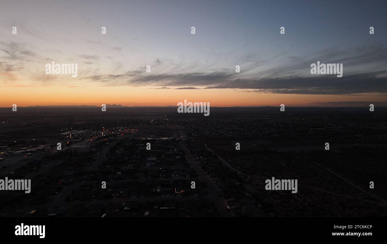 A stunning sunset illuminating the silhouette of a small town, creating ...