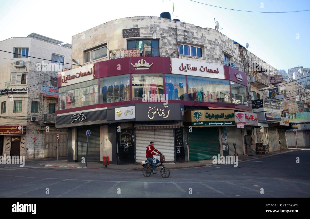 People walk past shuttered shops during a general strike in solidarity ...