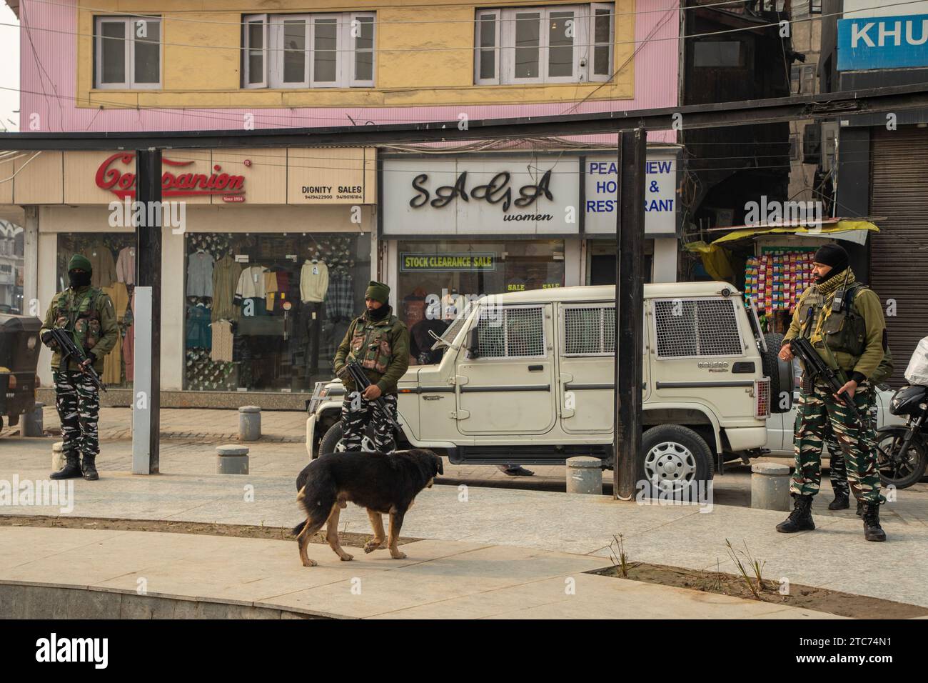 Indian paramilitary personnel stand guard along a road in Srinagar ...