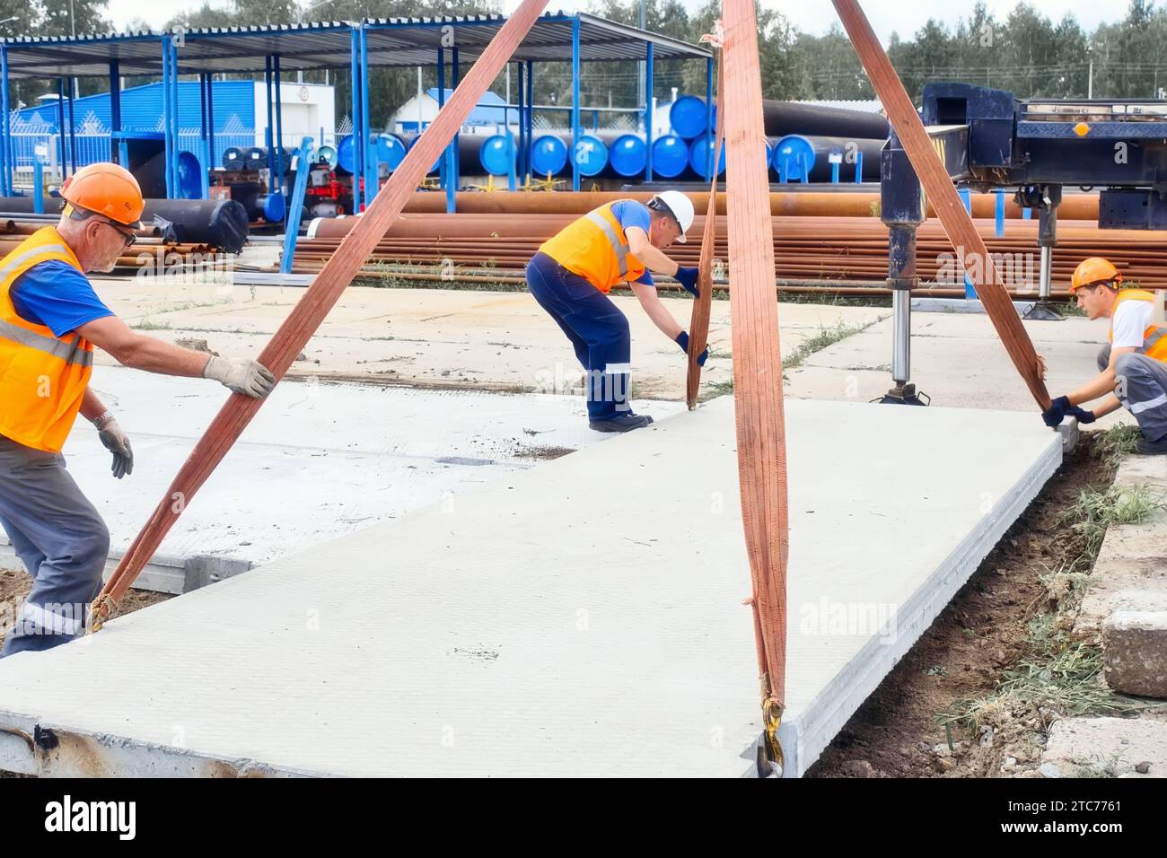 Professional builders work on construction site. Team of slingers lay ...