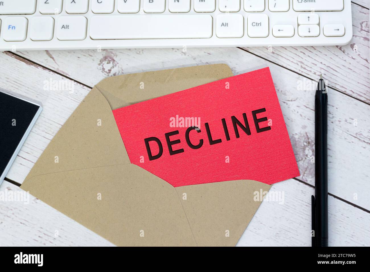 Decline text on red card with envelope, white keyboard and pen on ...