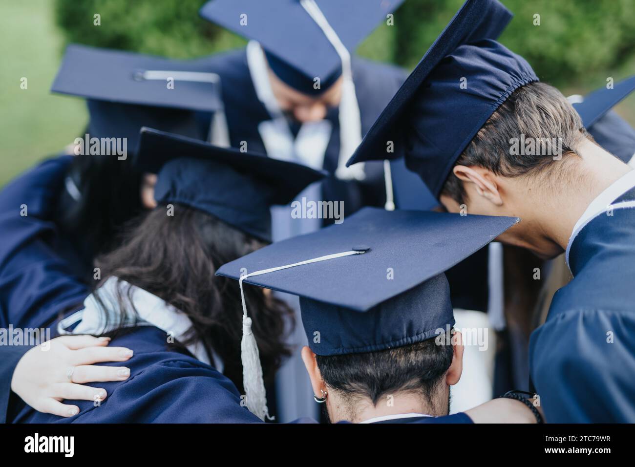 Faculty students celebrate graduation in the park, smiling and hugging ...