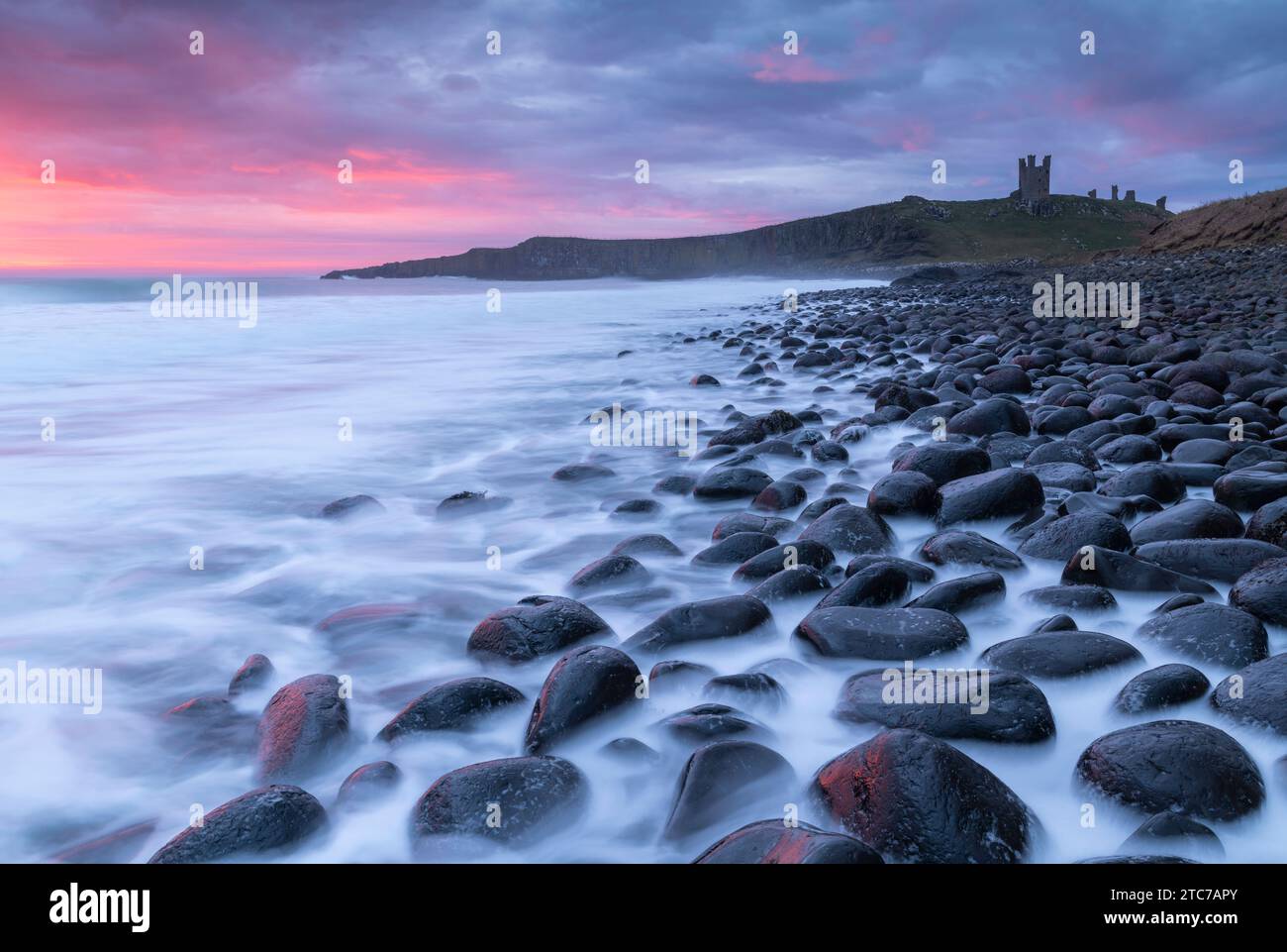 Beautiful pink dawn sky above Dunstanburgh Castle, photographed from ...