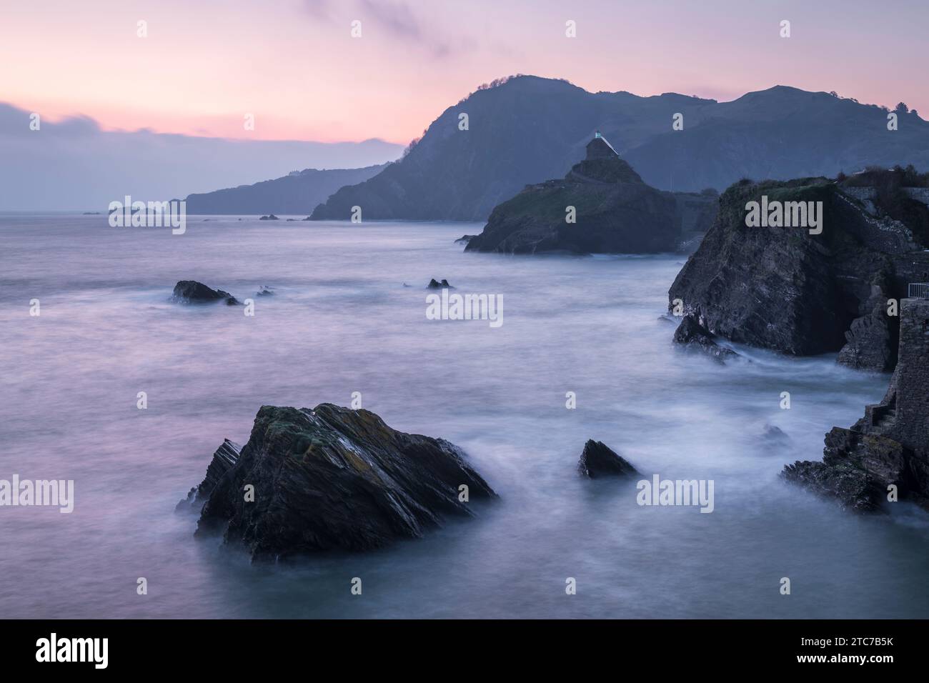 Dawn pink sky above Ilfracombe's rugged coast from Capstone Hill ...