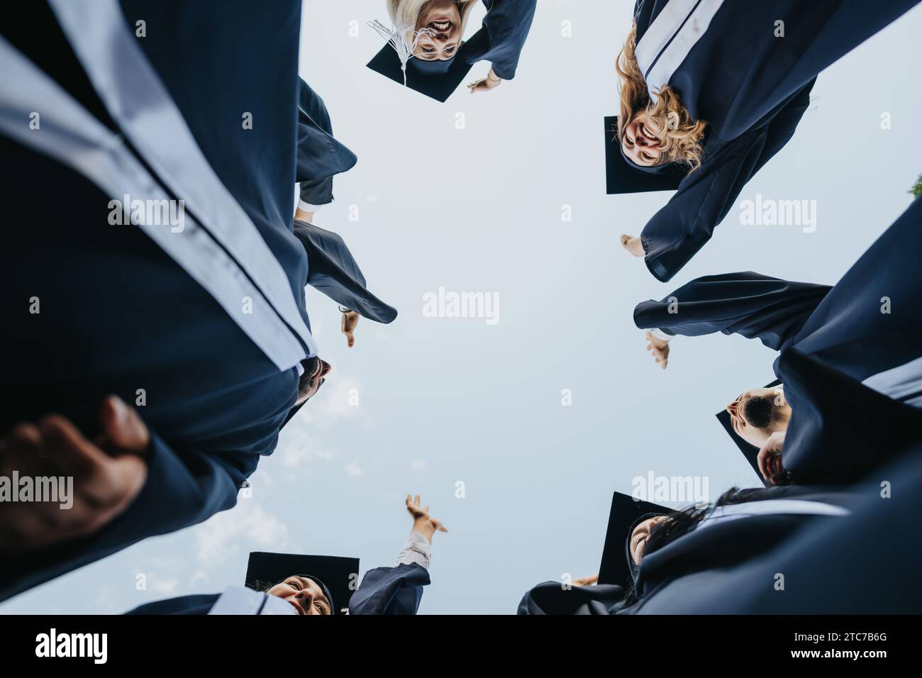 Students putting their hands together after graduation Stock Photo - Alamy