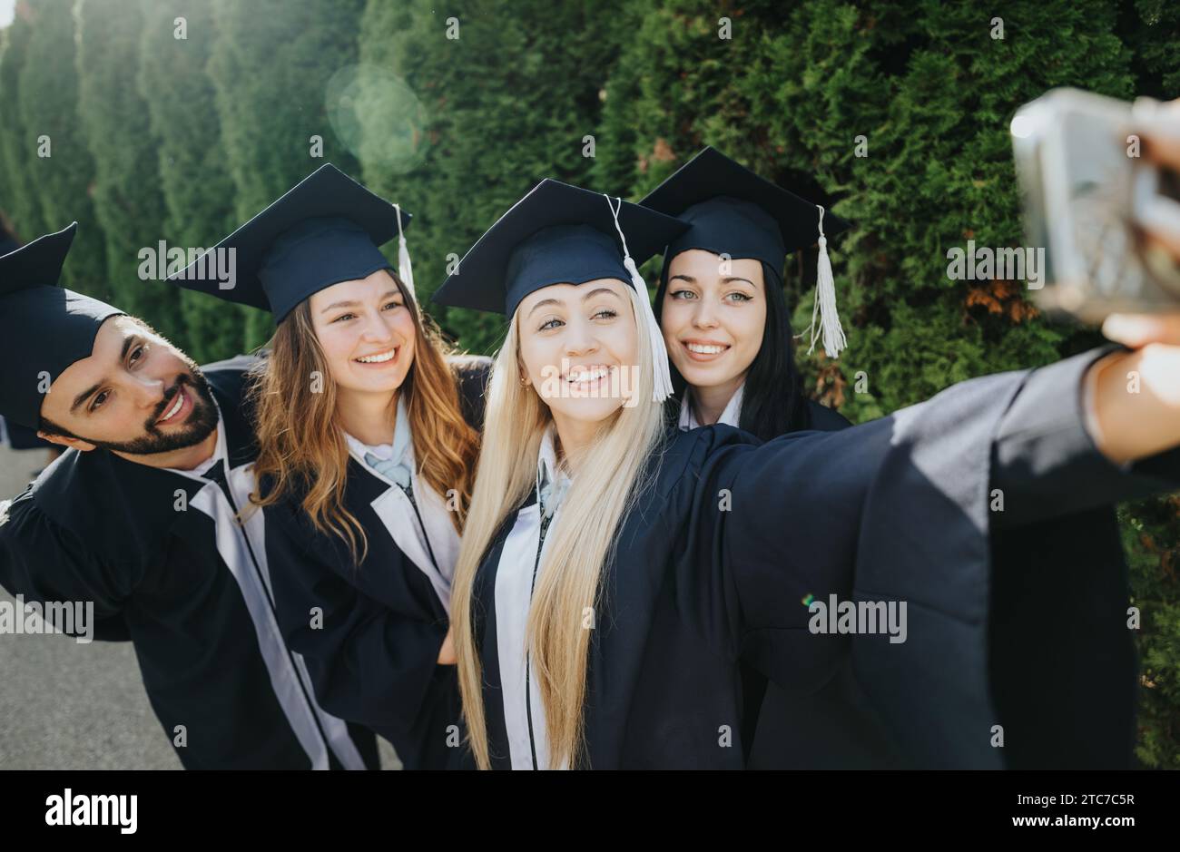 Graduated students celebrate their achievement wearing gowns and ...