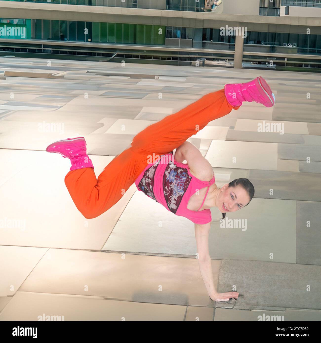 Female Hip hop Dancer balances on one hand in an urban environment ...